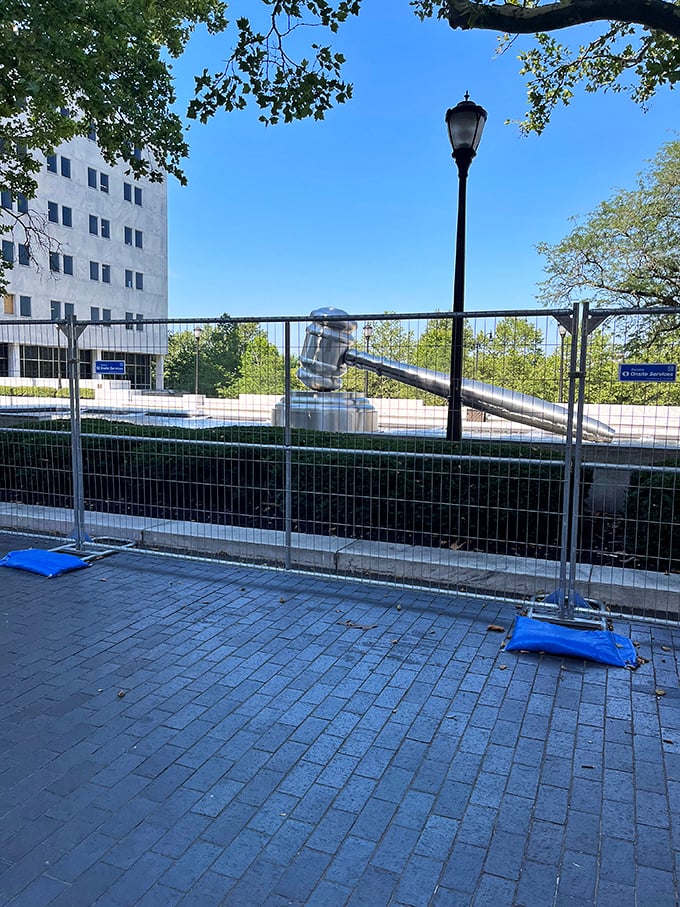 Even behind temporary fencing, the gavel commands attention—proof that great public art shines through any obstacle.