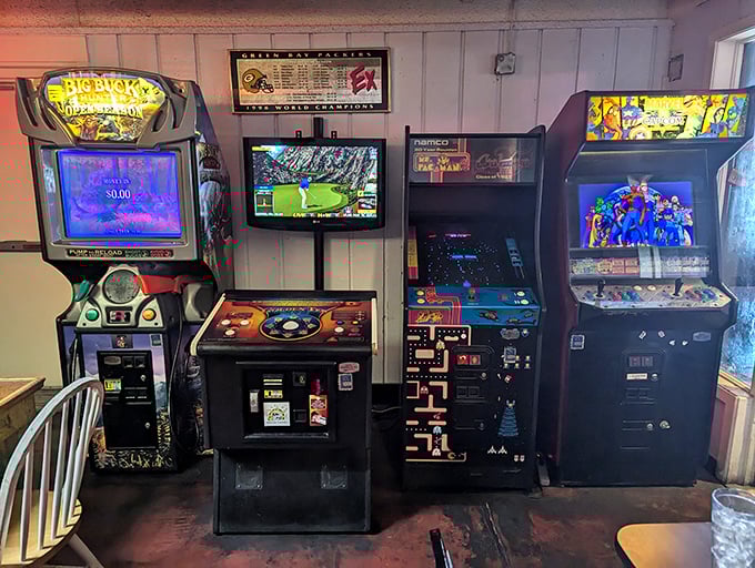 The arcade corner—where grown adults suddenly remember they're just tall children who now have money to feed their Pac-Man obsessions.