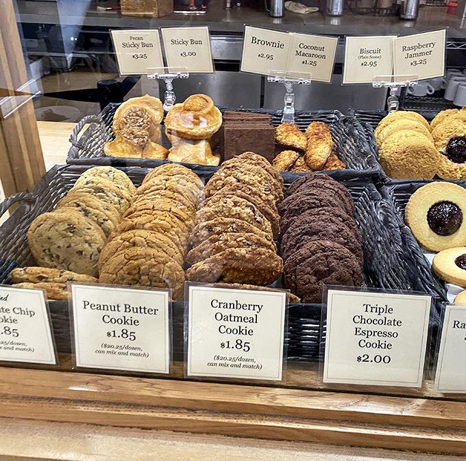Cookie diplomacy at its finest—where peanut butter, cranberry oatmeal, and chocolate espresso coexist peacefully behind glass, awaiting your selection.
