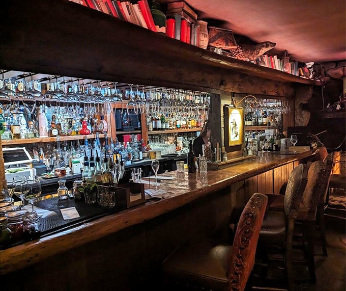 The bar doesn't just serve drinks—it crafts liquid companions for your meal. Those glasses hanging above promise sophisticated refreshment.