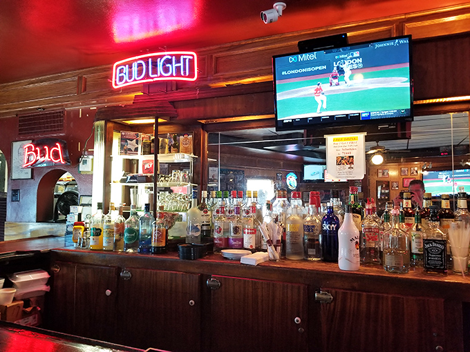A bar stocked for serious business—where neon beer signs provide the ambiance and cold drinks flow with reassuring regularity.