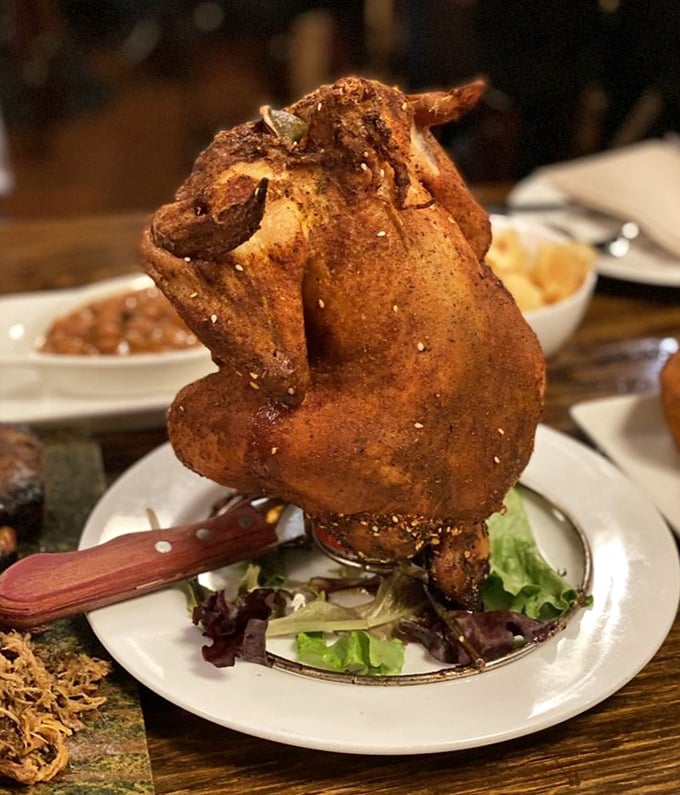 The legendary Beer Can Chicken arrives standing proud, a crispy-skinned monument to the marriage of poultry and brewing ingenuity.
