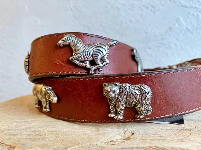 A leather belt adorned with safari animals—perfect for when your outfit needs to say "I'm sophisticated, but I also love The Lion King."