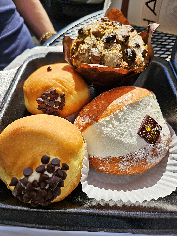 A dessert tray that doesn't just tempt—it practically pulls your wallet out for you. The chocolate-dotted donuts alone are worth the drive.