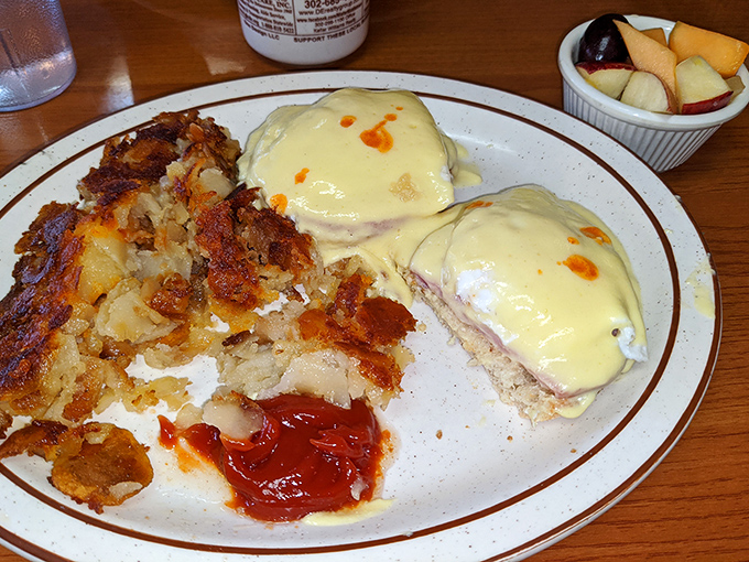 Eggs Benedict with a side of crispy hash browns and a dollop of ketchup for dipping. Breakfast doesn't get more classic – or more satisfying – than this.