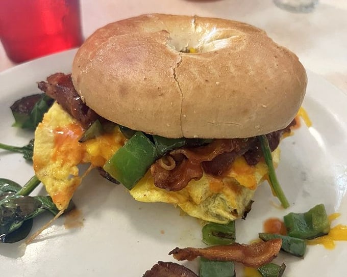 The breakfast sandwich—where a humble bagel becomes the stage for a morning performance of eggs, cheese, and vegetables in perfect harmony.