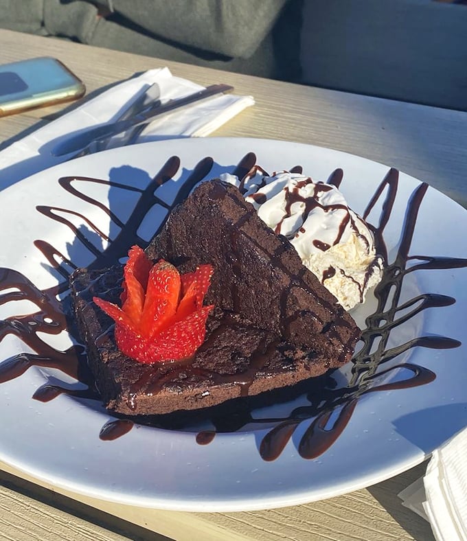 A chocolate brownie that's playing dress-up with strawberry and ice cream—the dessert equivalent of a beach vacation in formal wear.