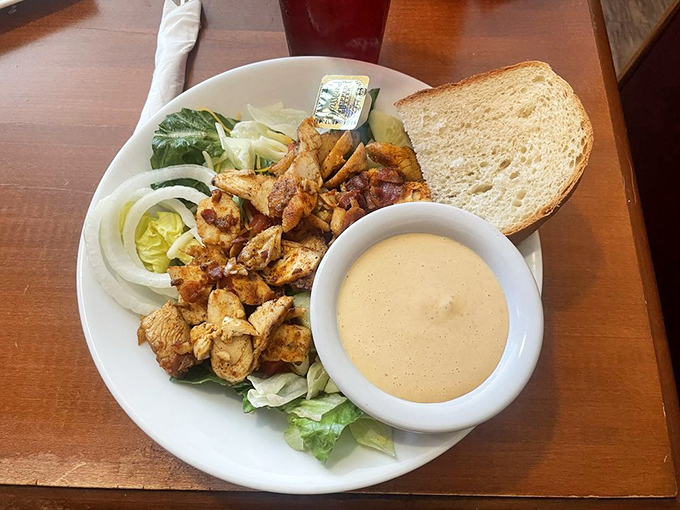 A chicken salad that doesn't apologize for being healthy. Seasoned chicken chunks, fresh greens, and that sauce—oh, that sauce deserves its own fan club.