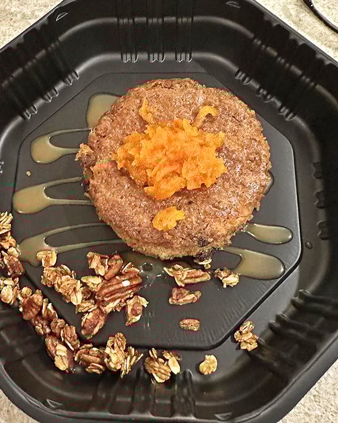 This dessert isn't just served—it's presented. A circle of cake surrounded by nuts, with what appears to be fruit compote. Sweet dreams are made of this.