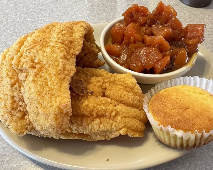 Golden fried catfish with candied yams and cornbread - a plate that makes you want to call your cardiologist just to brag.