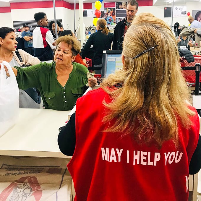 "May I help you" isn't just on the vest—it's the philosophy that makes this place special. Every purchase supports community programs.