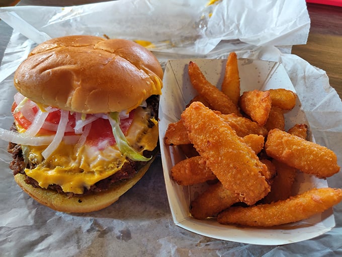 A proper cheeseburger with all the fixings alongside golden potato wedges—proof that sometimes the simplest pleasures are the most satisfying.