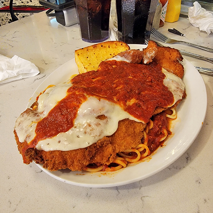 Chicken parmesan that doesn't mess around—a breaded cutlet buried under an avalanche of cheese and marinara, with spaghetti for backup.