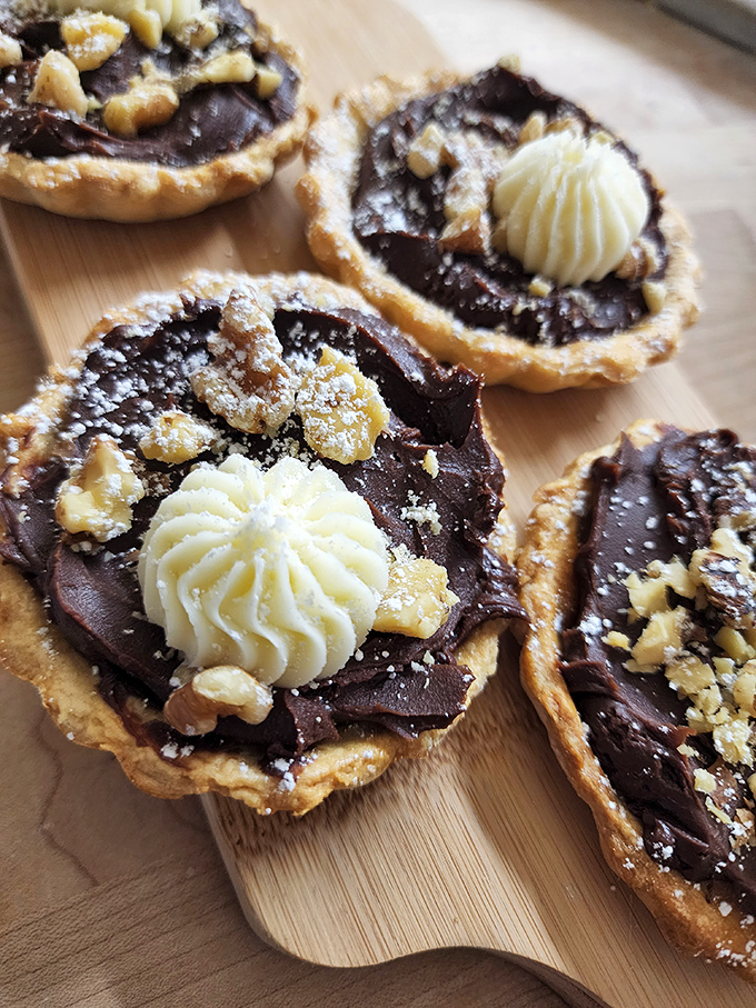 Chocolate tarts that belong in a museum of small pleasures, where the butter-to-chocolate ratio is considered a mathematical marvel.