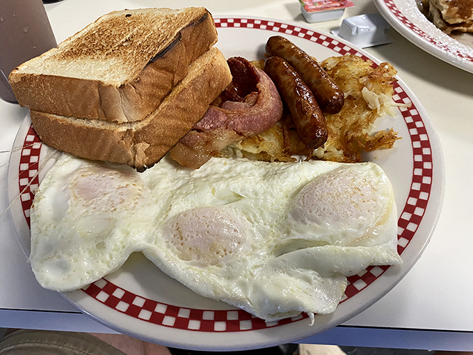 The classic breakfast plate—perfectly cooked eggs, golden toast, crispy hash browns, and breakfast meats arranged like a delicious solar system.