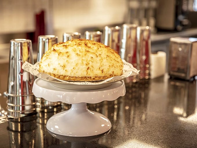 This coconut meringue pie doesn't just sit on its pedestal—it reigns from it, a cloud-like crown of toasted perfection that deserves its own country music ballad.