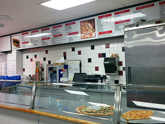 The ordering counter showcases pizza ready for hungry customers, with a menu board that requires multiple visits to fully explore.