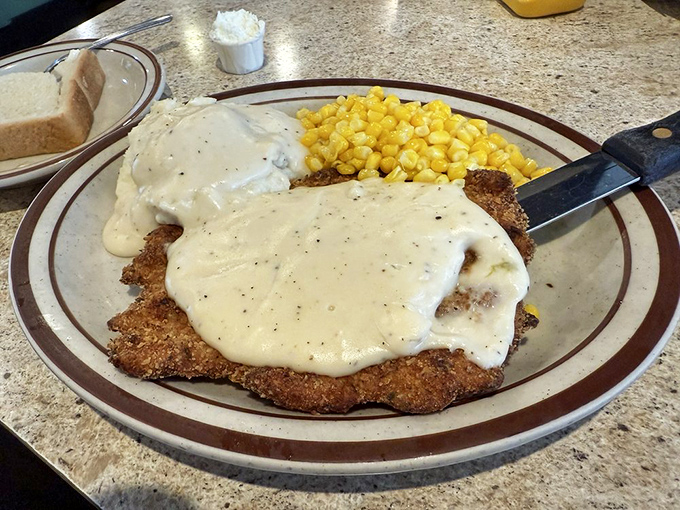 Country fried steak swimming in creamy gravy—comfort food that gives you a warm hug from the inside. That side of corn knows its supporting role perfectly.
