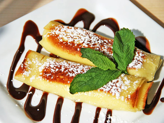 Sweet cheese pierogi with chocolate sauce isn't fusion cuisine—it's tradition in dessert form, where powdered sugar snow falls on pillowy dumplings.