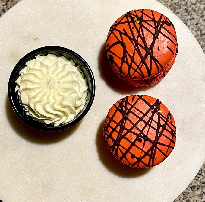 Desserts that make you want to start with the sweet stuff—vibrant macarons with artistic chocolate drizzles alongside a cloud of whipped cream.