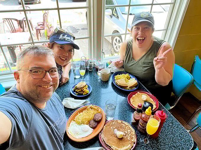 Happy diners showing off their breakfast bounty—the universal language of "you've got to try this" captured in one perfect moment.