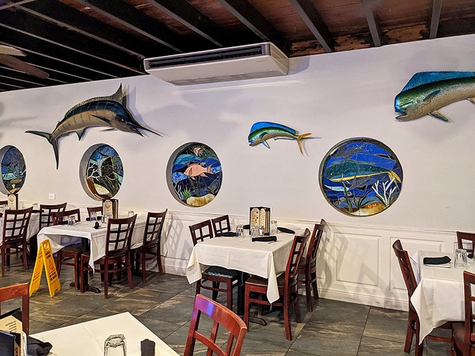 The dining room walls feature porthole art that transforms ordinary tables into oceanside experiences—like eating in a stylish submarine with excellent service.