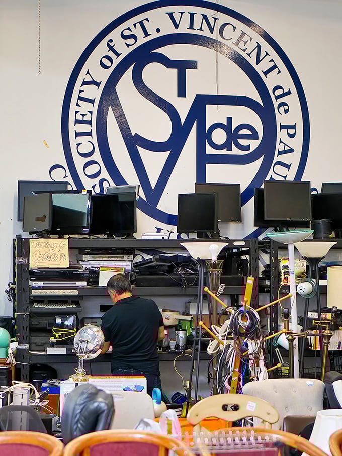 Electronics and lamps beneath the watchful eye of the St. Vincent de Paul logo—tested, approved, and ready for new homes.