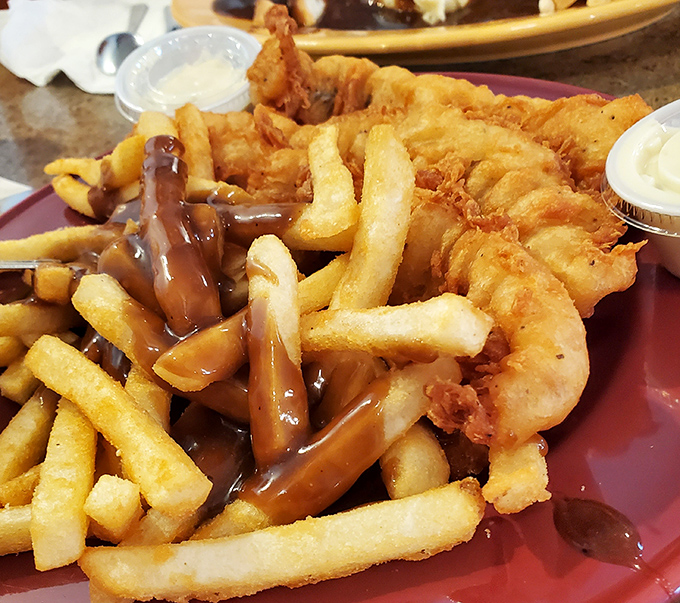 Fish and fries swimming in gravy—comfort food that speaks the universal language of "you deserve this deliciousness today."