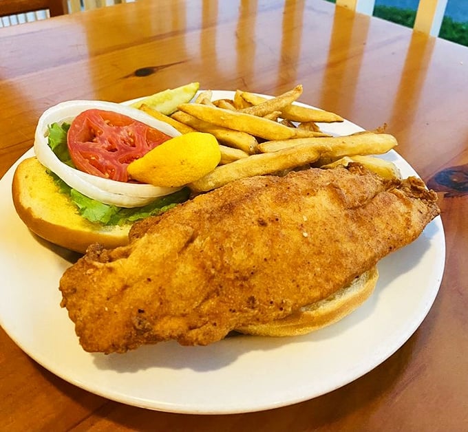 A fried grouper sandwich so substantial it requires a game plan. The golden-brown perfection hangs off the bun like it's showing off.