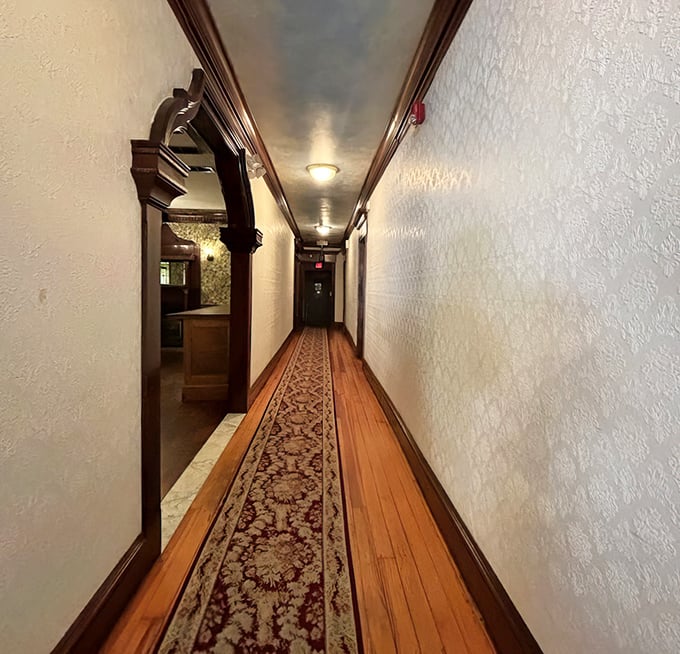 The hallway's vintage charm hints at the building's history—wooden floors and ornate runner creating a pathway to dining satisfaction.