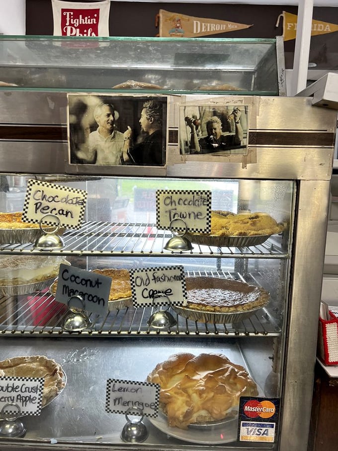 The pie case—a glass-fronted gallery exhibiting edible masterpieces with handwritten labels that promise homemade perfection in every slice.