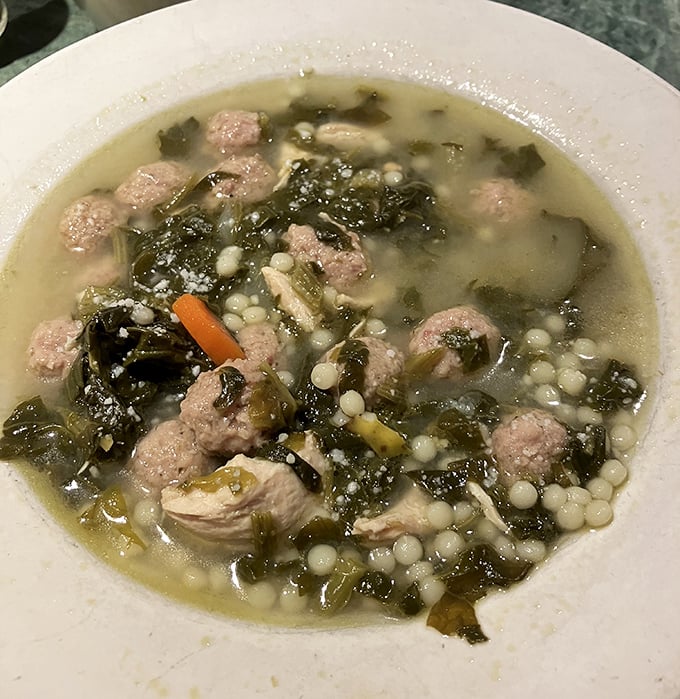 Wedding soup that grandmothers would approve of—tiny meatballs swimming with escarole in broth that tastes like someone's been stirring it since morning.