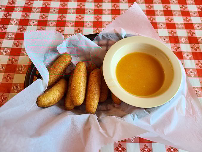 Hushpuppies—golden-fried cornmeal pillows that somehow make silence delicious. The perfect dipping sauce makes them disappear even faster.