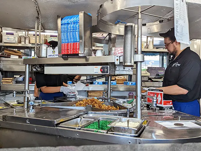 The kitchen reveals the organized chaos where Chicago's iconic hot dogs come to life—a symphony of condiments conducted with practiced precision. 