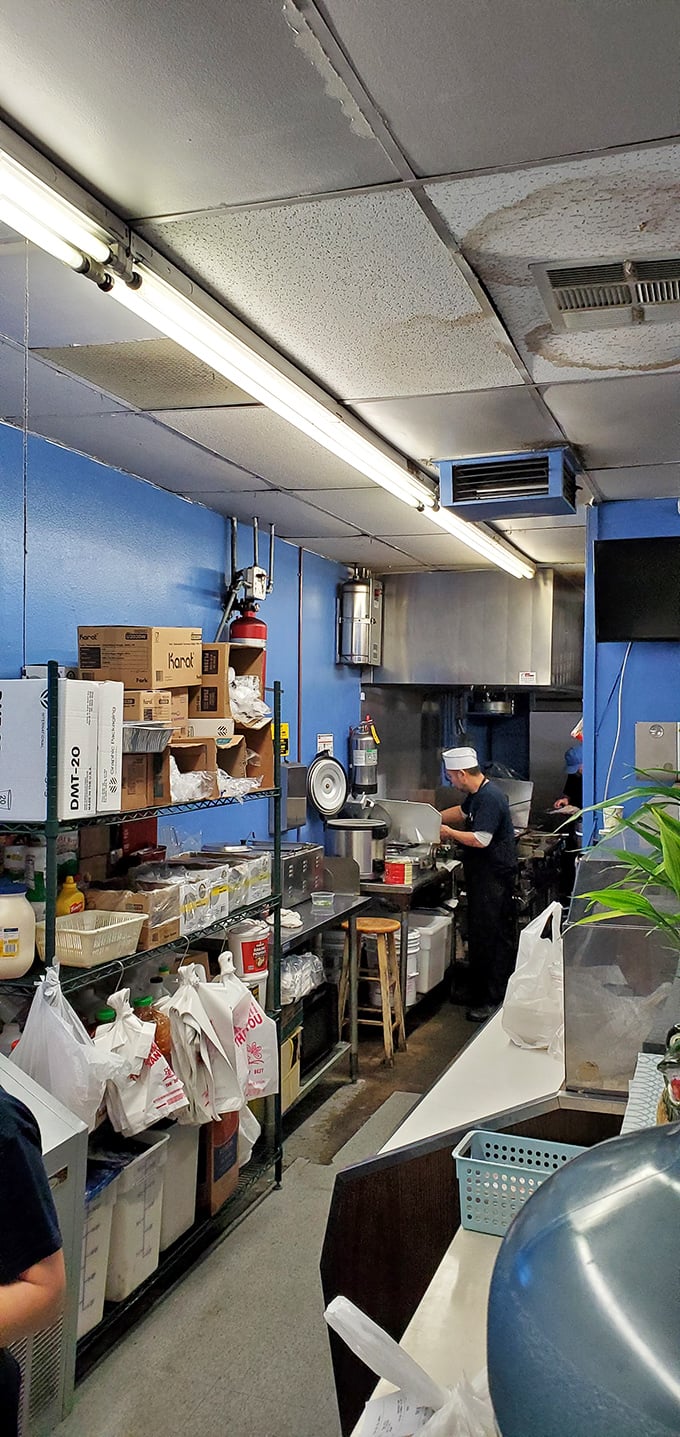 The kitchen: where magic happens in tight quarters. No wasted motion, just practiced hands creating flavor bombs with every dish.