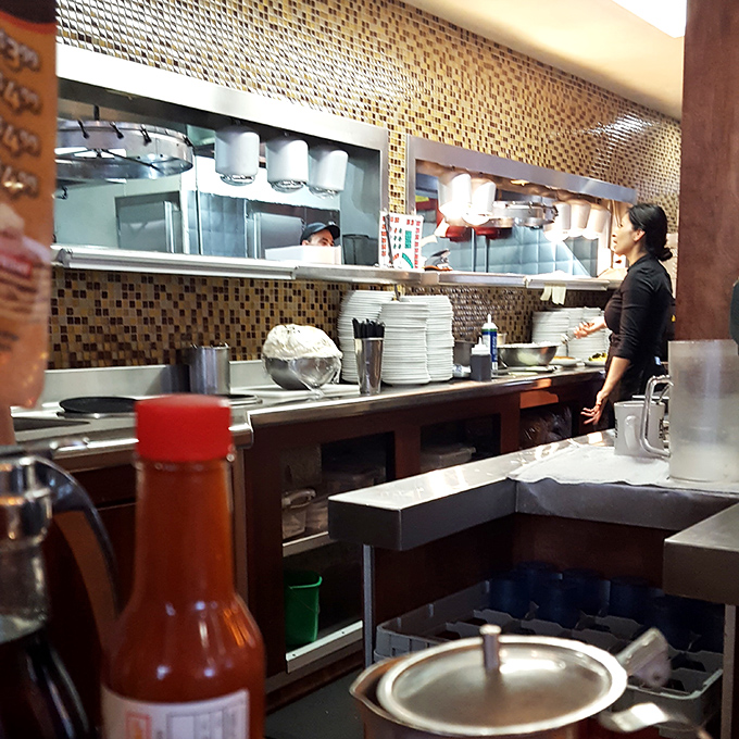 Where breakfast magic happens. The open kitchen design lets you witness the choreography of short-order cooking—a delicious dance that ends on your plate.