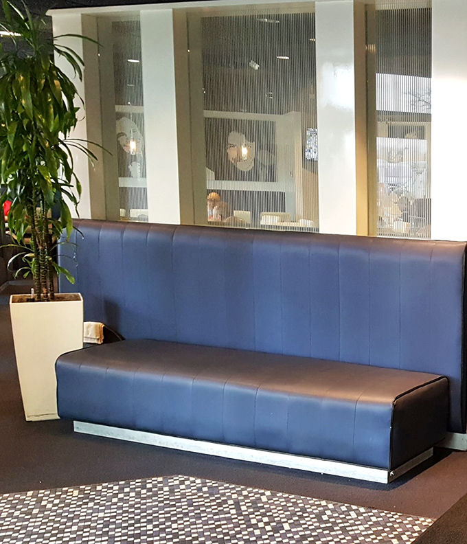 Blue booth seating and strategic dividers create intimate dining spaces—perfect for both serious conversations and serious eating.