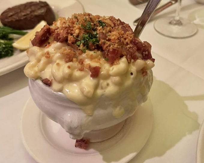 Mac and cheese that's clearly been to finishing school—crowned with crispy bits and threatening to steal attention from your steak.
