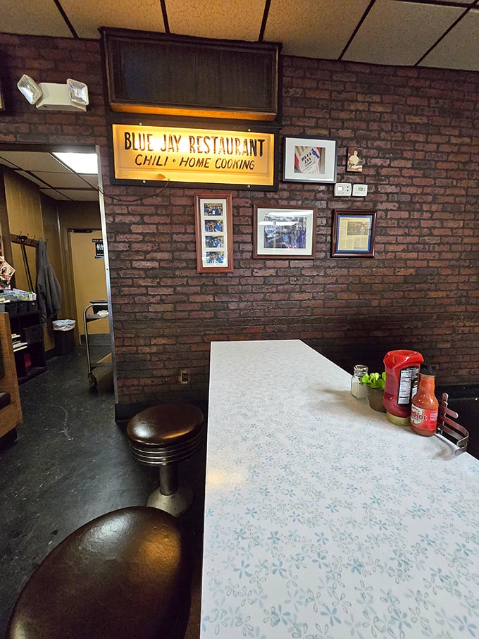 The exposed brick wall adorned with the Blue Jay sign tells stories of countless meals shared in this Cincinnati institution.