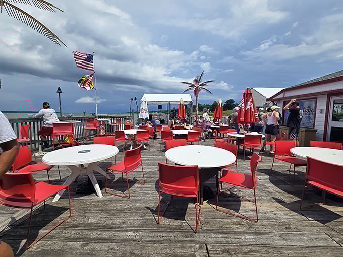 Outdoor dining where red chairs pop against the blue sky. The perfect spot to enjoy seafood while boats drift by on the Potomac.
