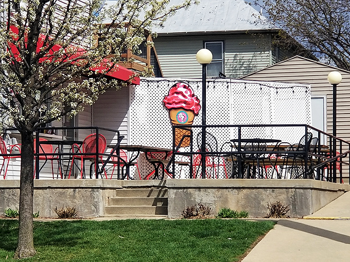 Spring blossoms, red tables, and an ice cream cone sign—this outdoor seating area practically screams "Summer in the Midwest is here!"