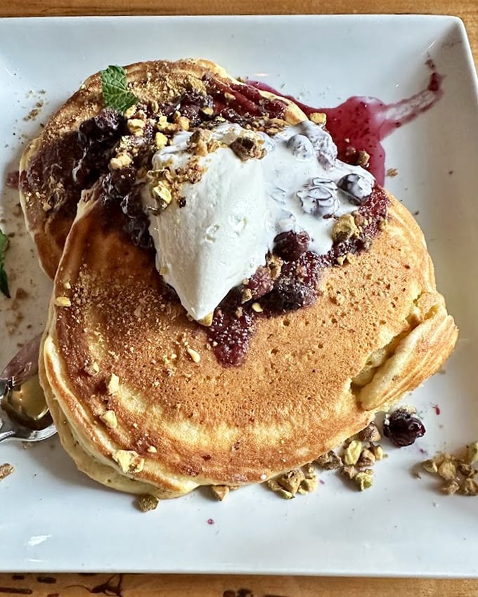 These pancakes don't merely arrive at your table – they make an entrance, topped with berries and cream that transform breakfast into an event worth dressing for.