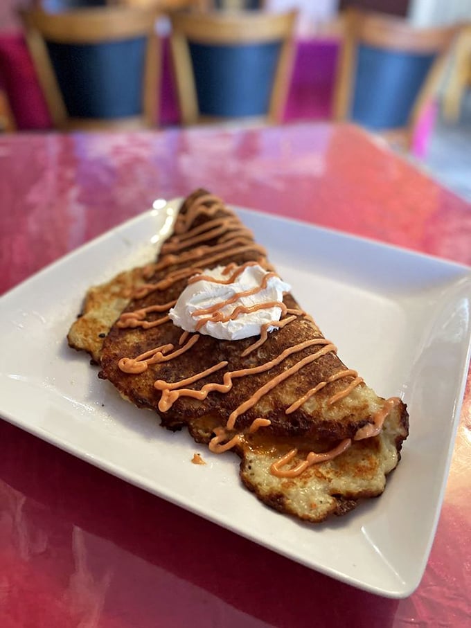 This isn't just a potato pancake – it's a crispy, golden canvas for sweet sauce and whipped cream, proving potatoes have a serious dessert potential. 