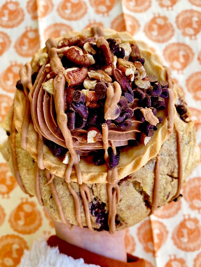 A cookie masterpiece crowned with chocolate frosting and nuts—proof that sometimes the best things in life require both hands and several napkins.