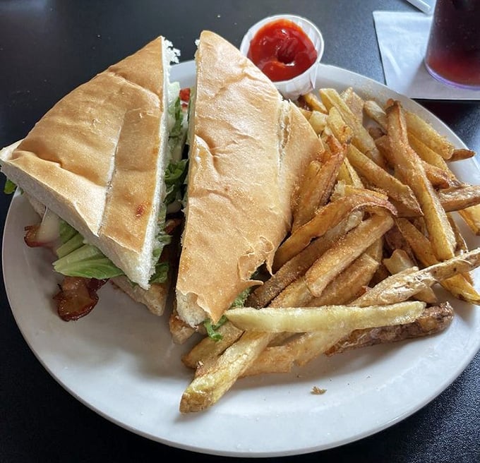 This sandwich isn't just lunch; it's architecture – layers of goodness between bread with fries so perfectly golden they deserve their own spotlight.