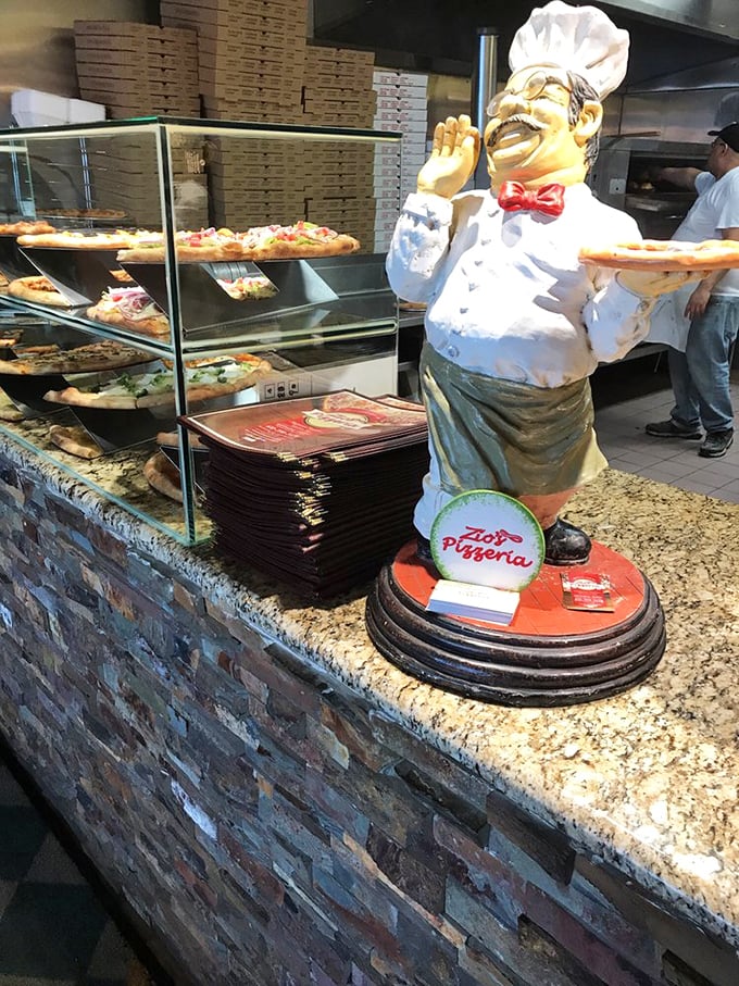 The chef statue stands guard over pizza perfection. A silent sentinel ensuring quality in every bite.