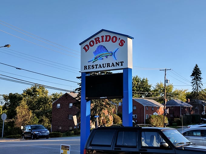 The roadside sign stands tall and proud, featuring Dorido's signature sailfish—a blue-and-white promise of the ocean's bounty waiting inside.