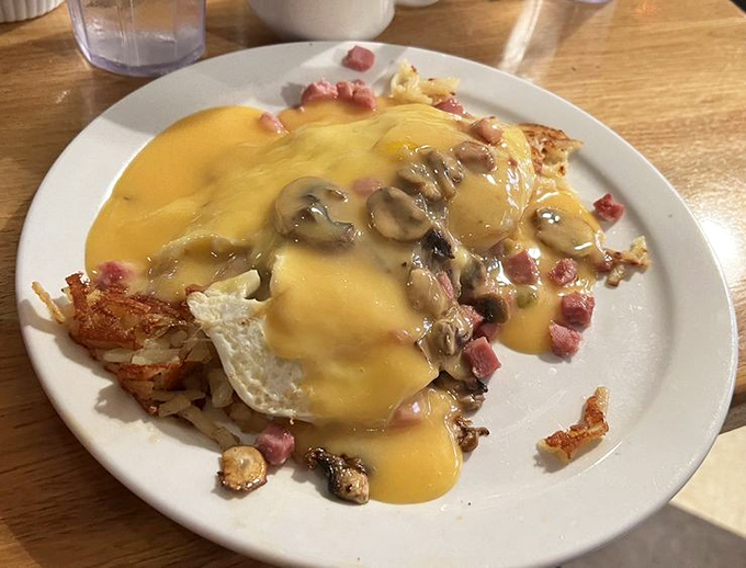 This isn't just breakfast—it's a golden-hued masterpiece where cheese, eggs, and ham perform a symphony on crispy hash browns.