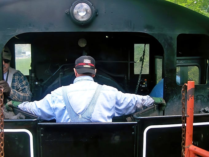 A dedicated crew member tends to the locomotive controls – part of the passionate team keeping railroad heritage alive for new generations to experience.