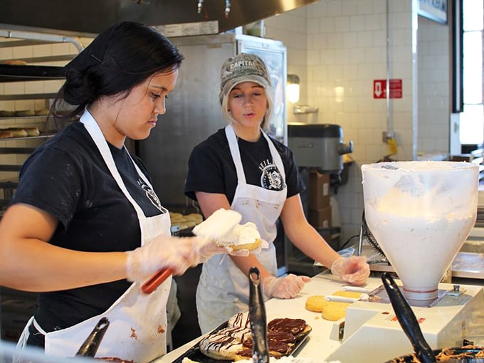 Skilled hands craft each donut with practiced precision—the human touch that no machine could ever replicate.